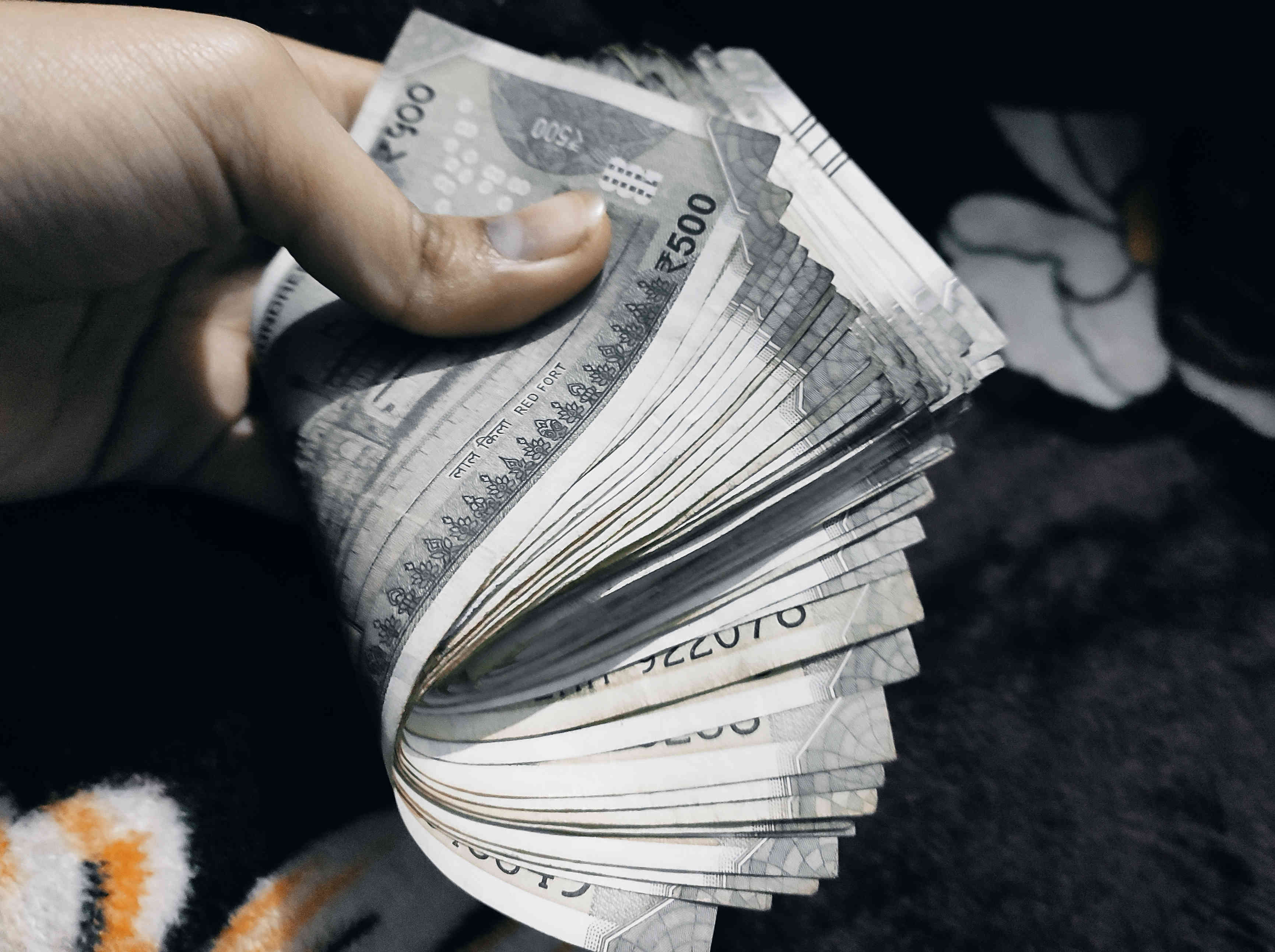 This image contains a hand holding a stack | StudyX